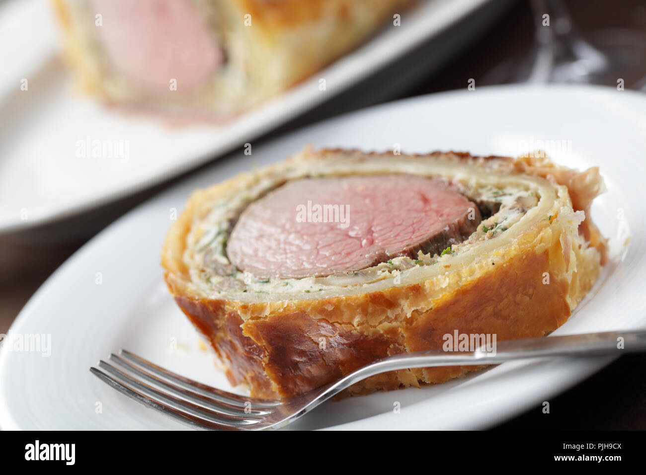 Slice of rare Beef Wellington on the plate closeup Stock Photo - Alamy