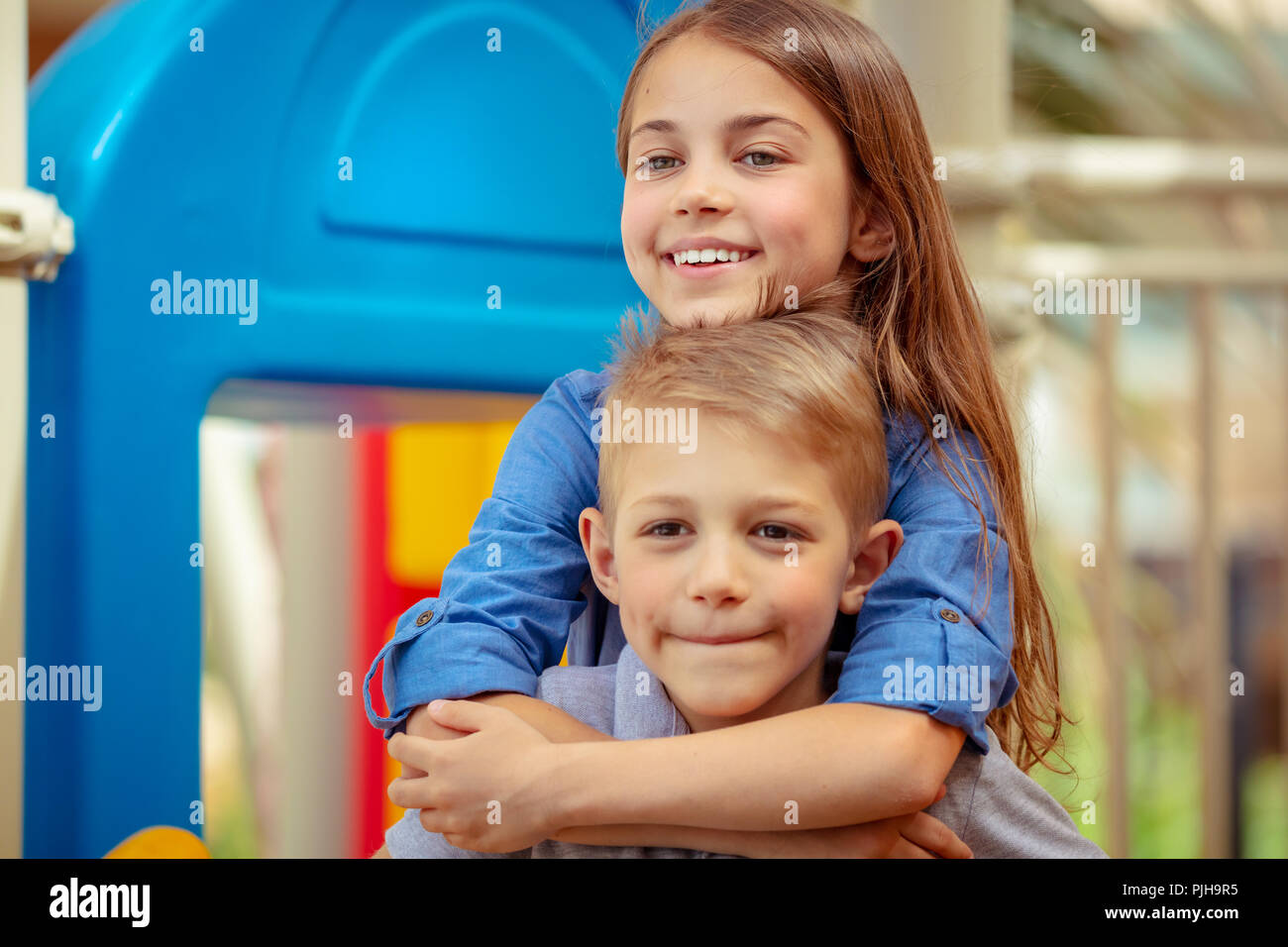 Portrait of a cute siblings having fun together on playground, brother ...