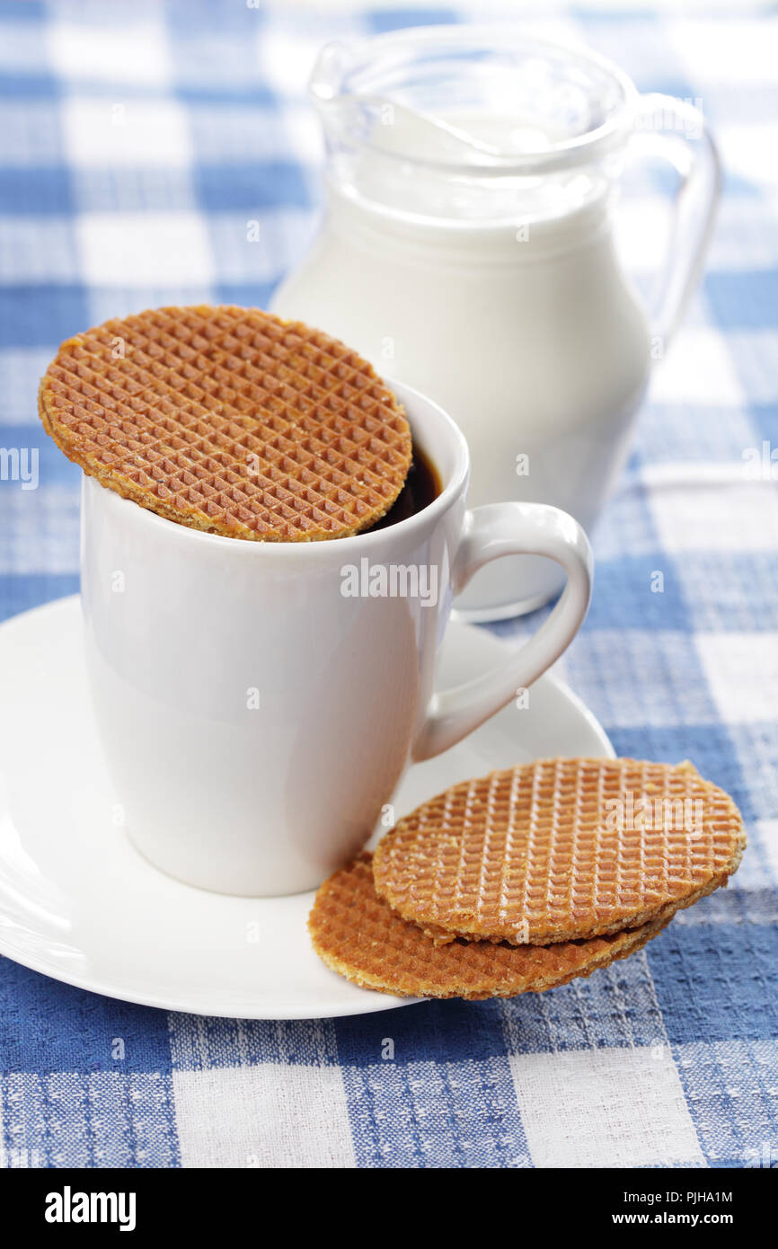 Stroopwafel on the cup of coffee and the jug with milk Stock Photo - Alamy