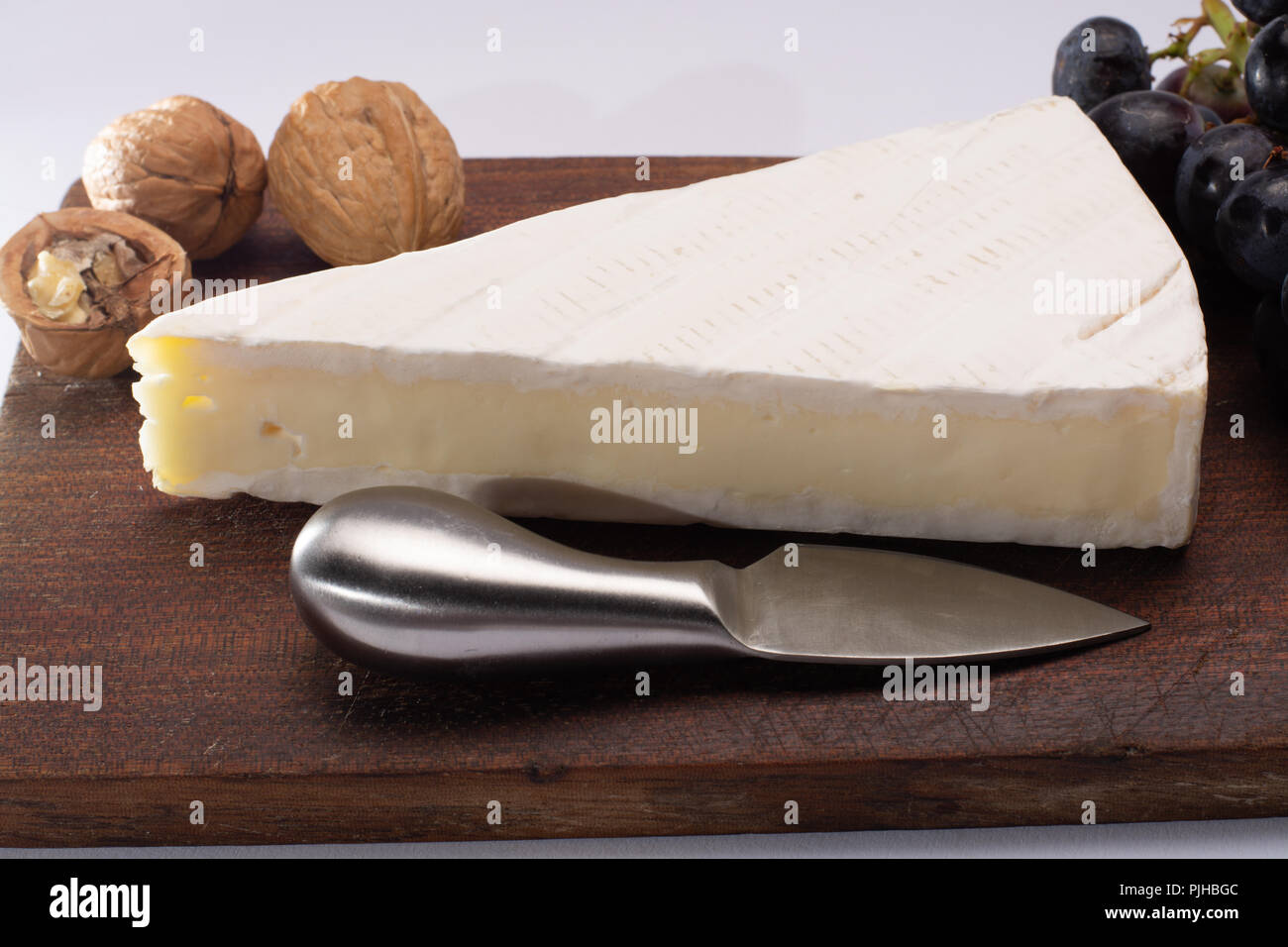 Piece of french soft-ripened white mold cow milk cheese brie produced ...