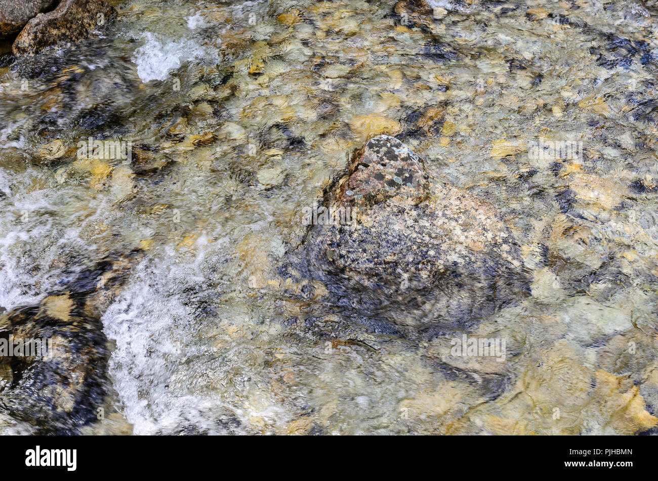 Mountain river. The texture of the rocky bottom is visible Stock Photo ...