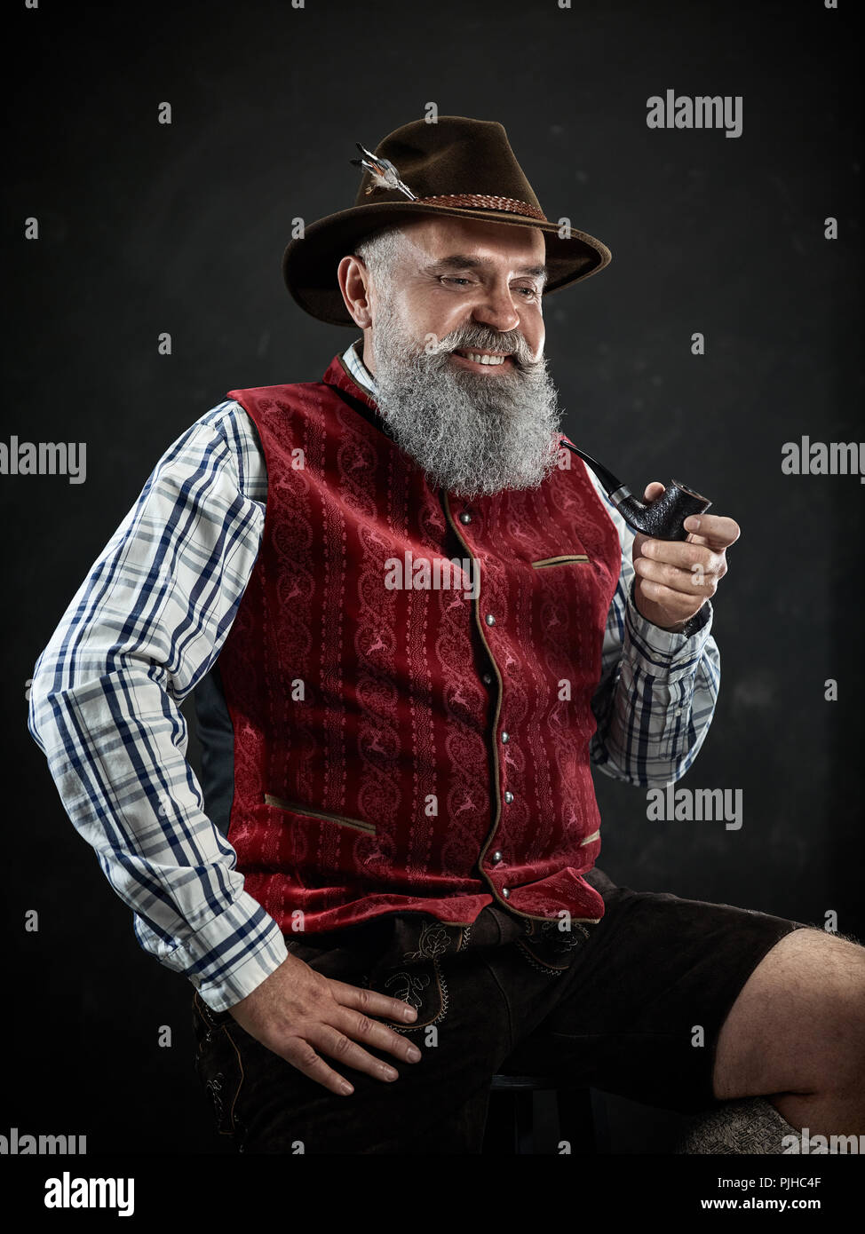 dramatic portrait of gray bearded senior man in hat smoking tobacco ...