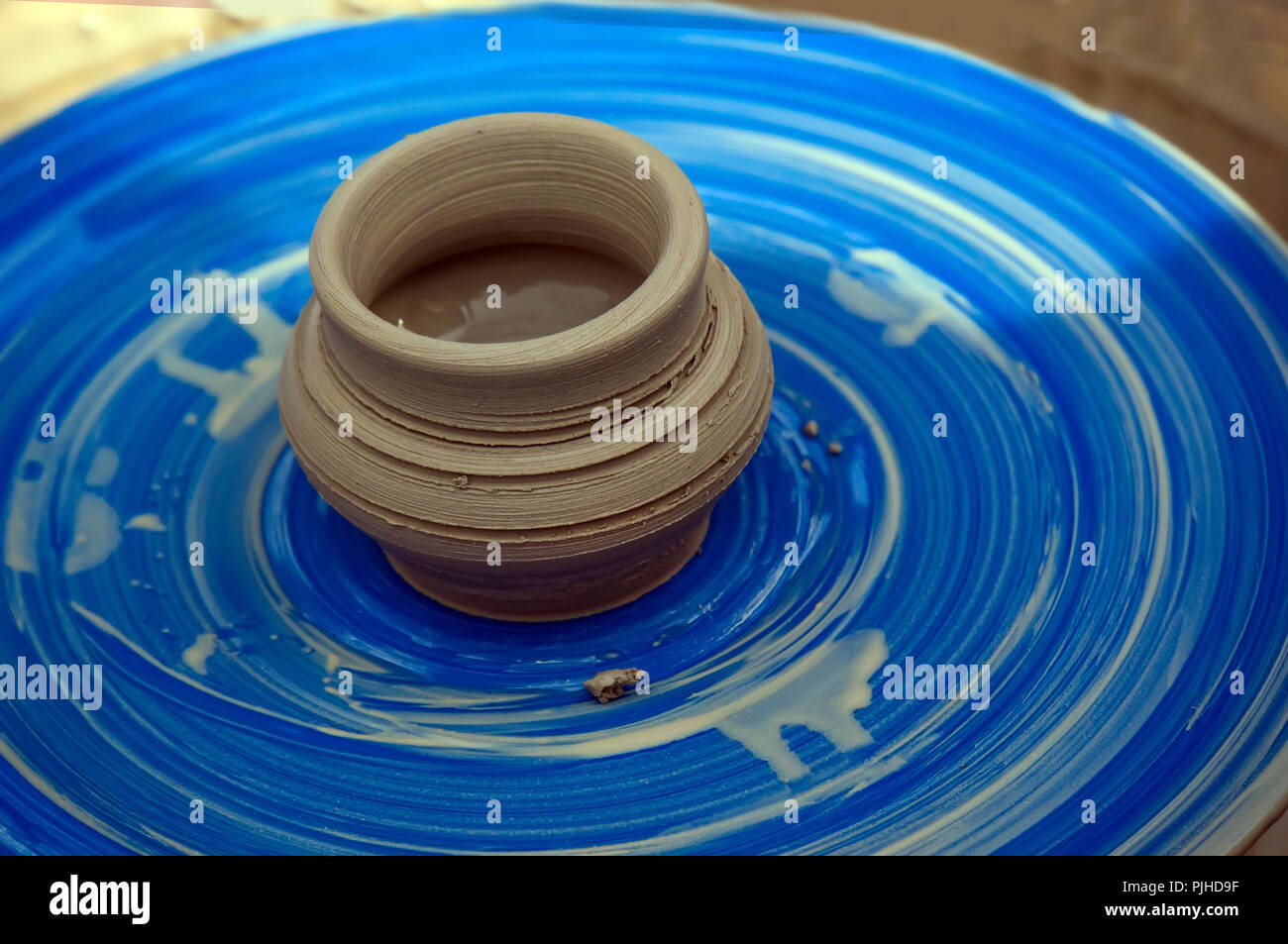 a clay pitcher on a Potter's wheel. The old craft of pottery making ...