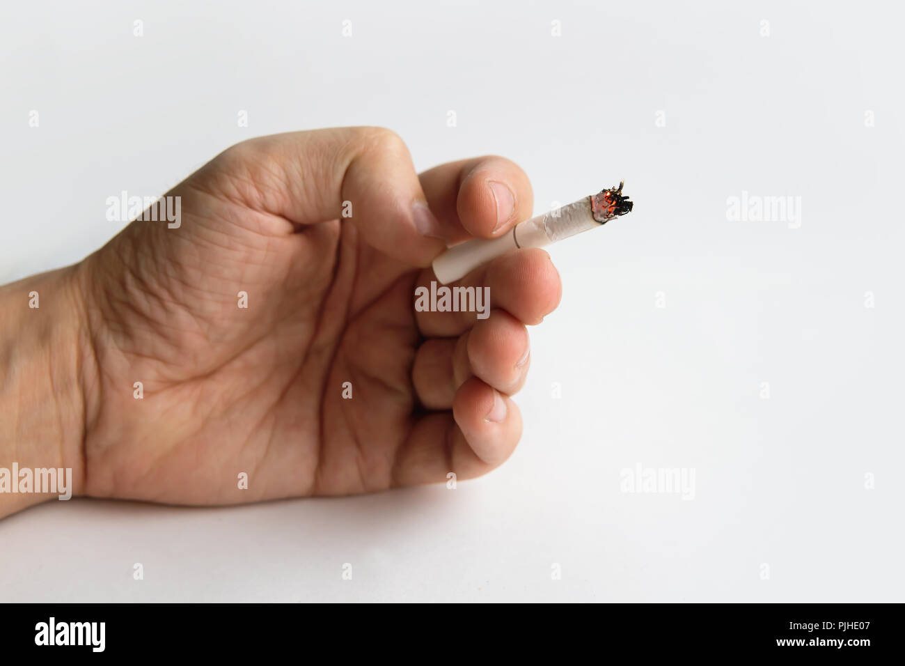 Close-up of cigarette is in the hand of man. Isolated and copy space in ...