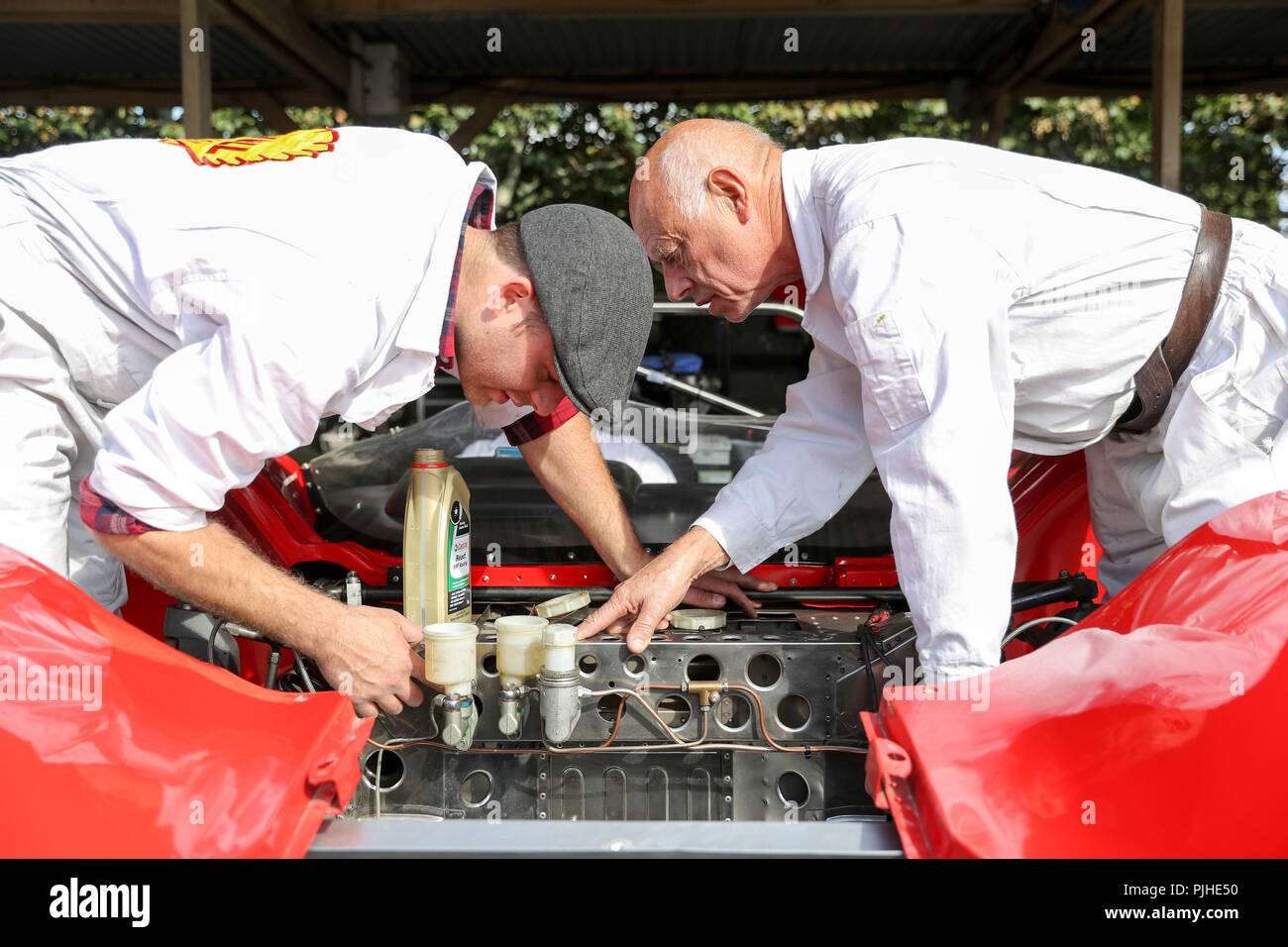 Mechanics work on the engine of a 1965 Lola-Chevrolet T70 Spyder on day ...