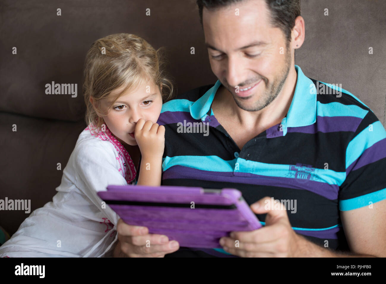 Girl with his father playing with an Ipad Stock Photo - Alamy