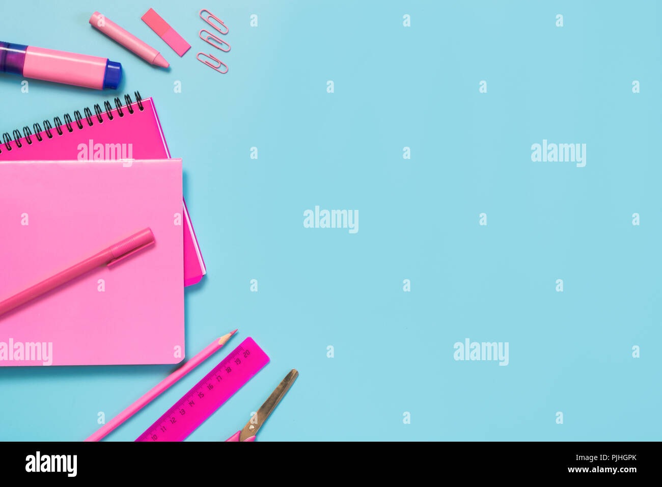 Pink girlish school supplies, notebooks and pens on punchy blue. Top ...