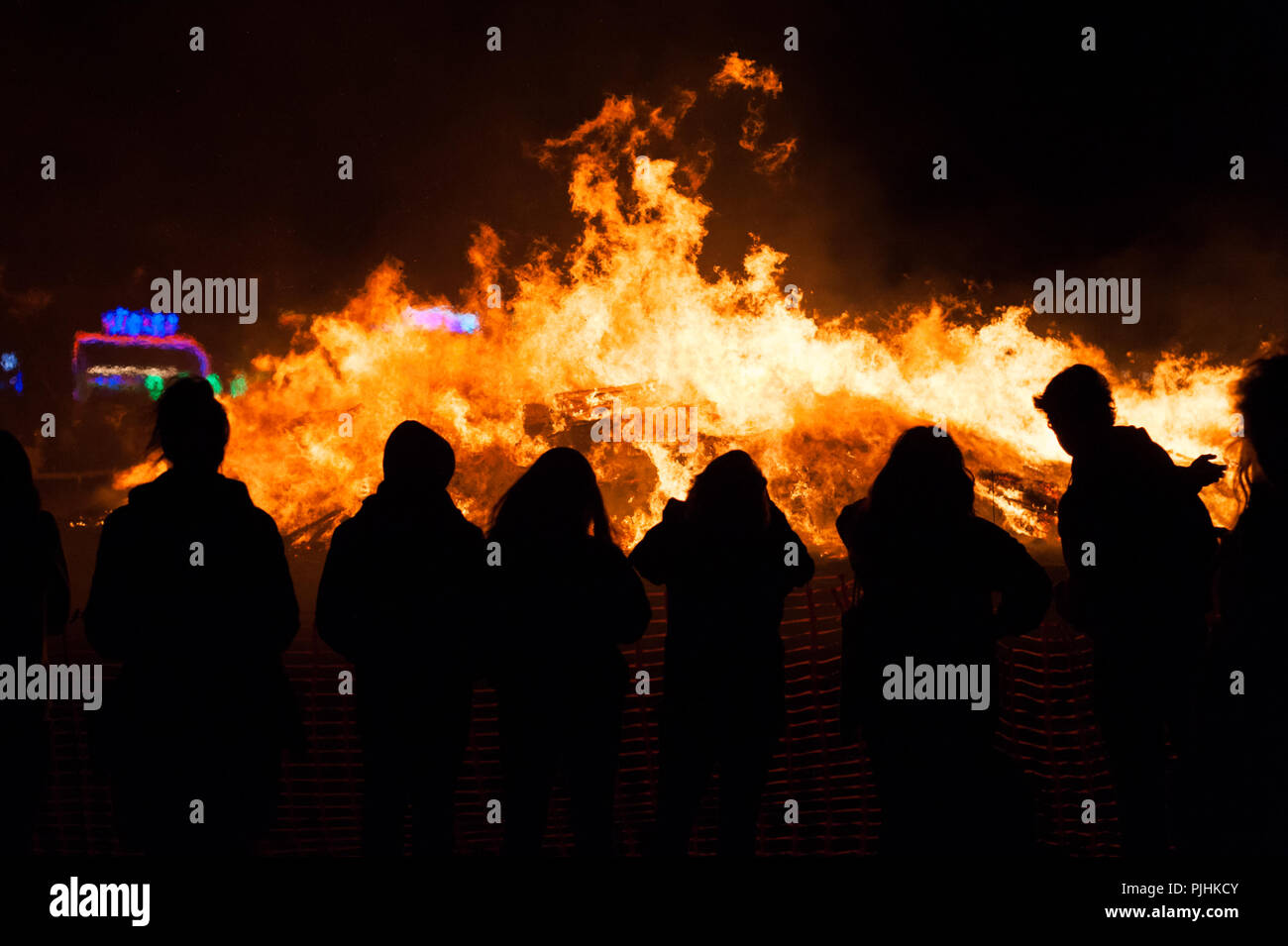 People are silhouetted against the flames of a large bonfire on the 5th ...