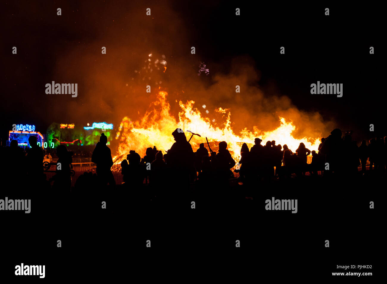 People are silhouetted against the flames of a large bonfire on the 5th ...