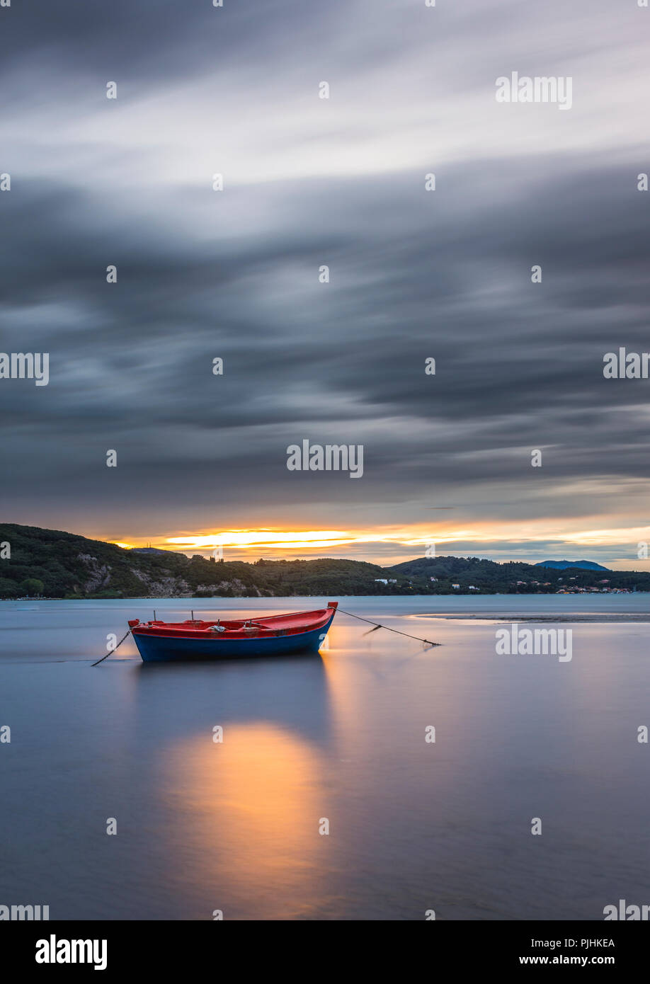 Long exposure shot of an isolated boat at sunset Stock Photo - Alamy