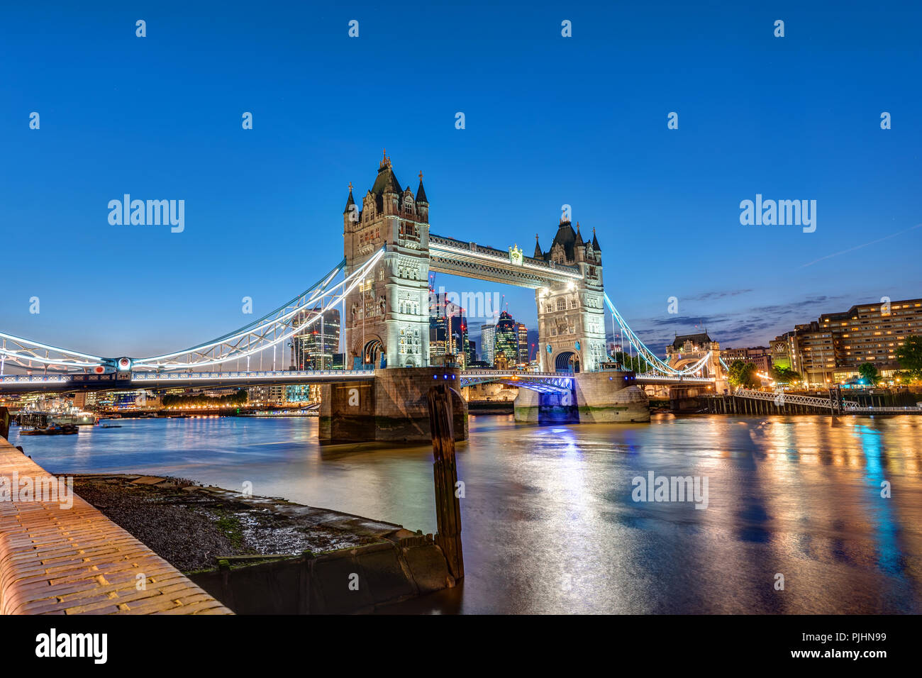 The Tower Bridge in London at night with the City in the back Stock ...