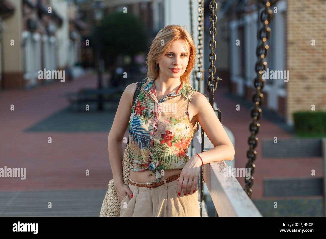 Beautiful young woman in tropical shirt, beige galligaskins with wicked ...