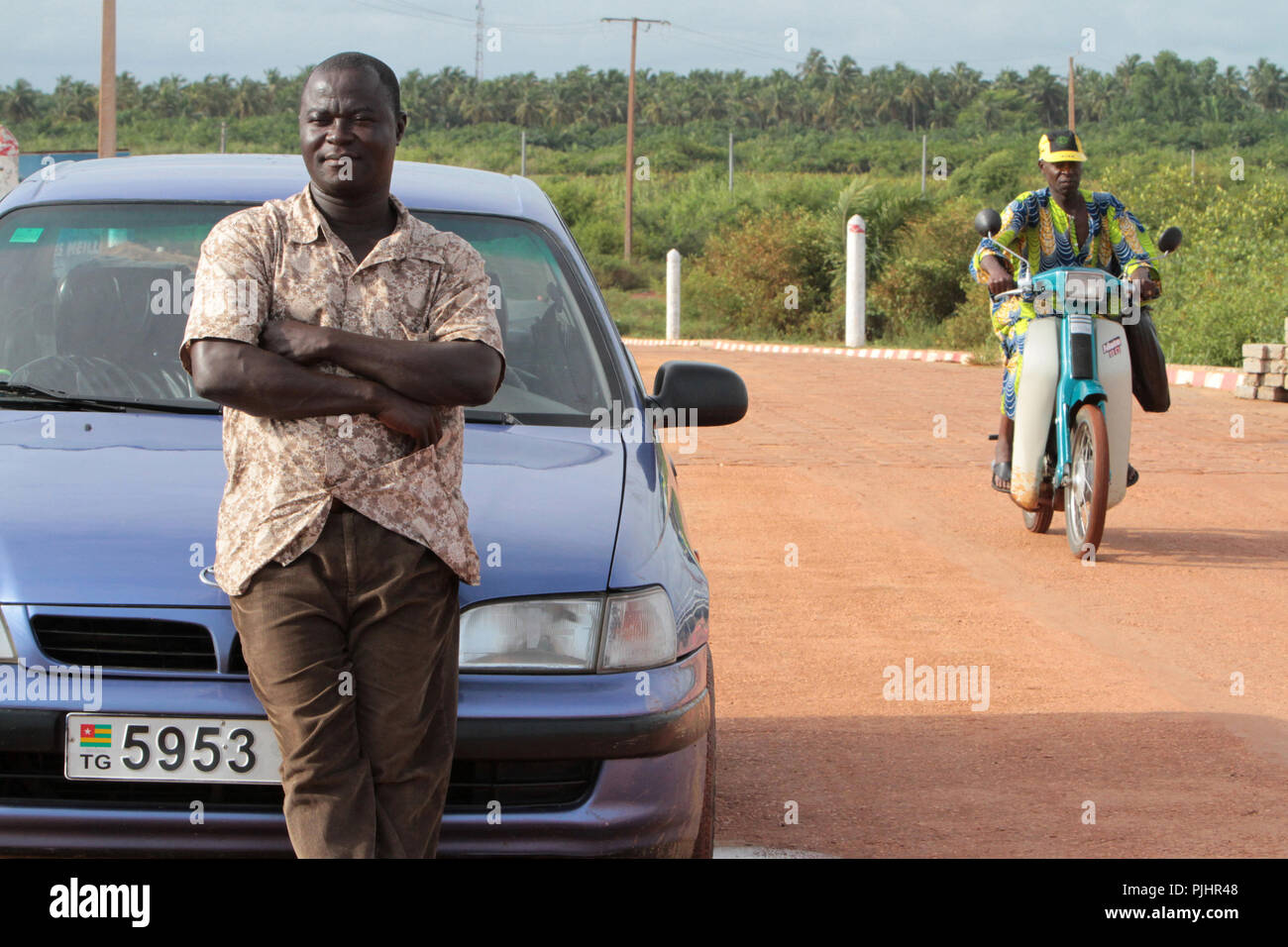 Taxi Benin sitting on the hood of his vehicle. Ouidah. Benin Stock ...