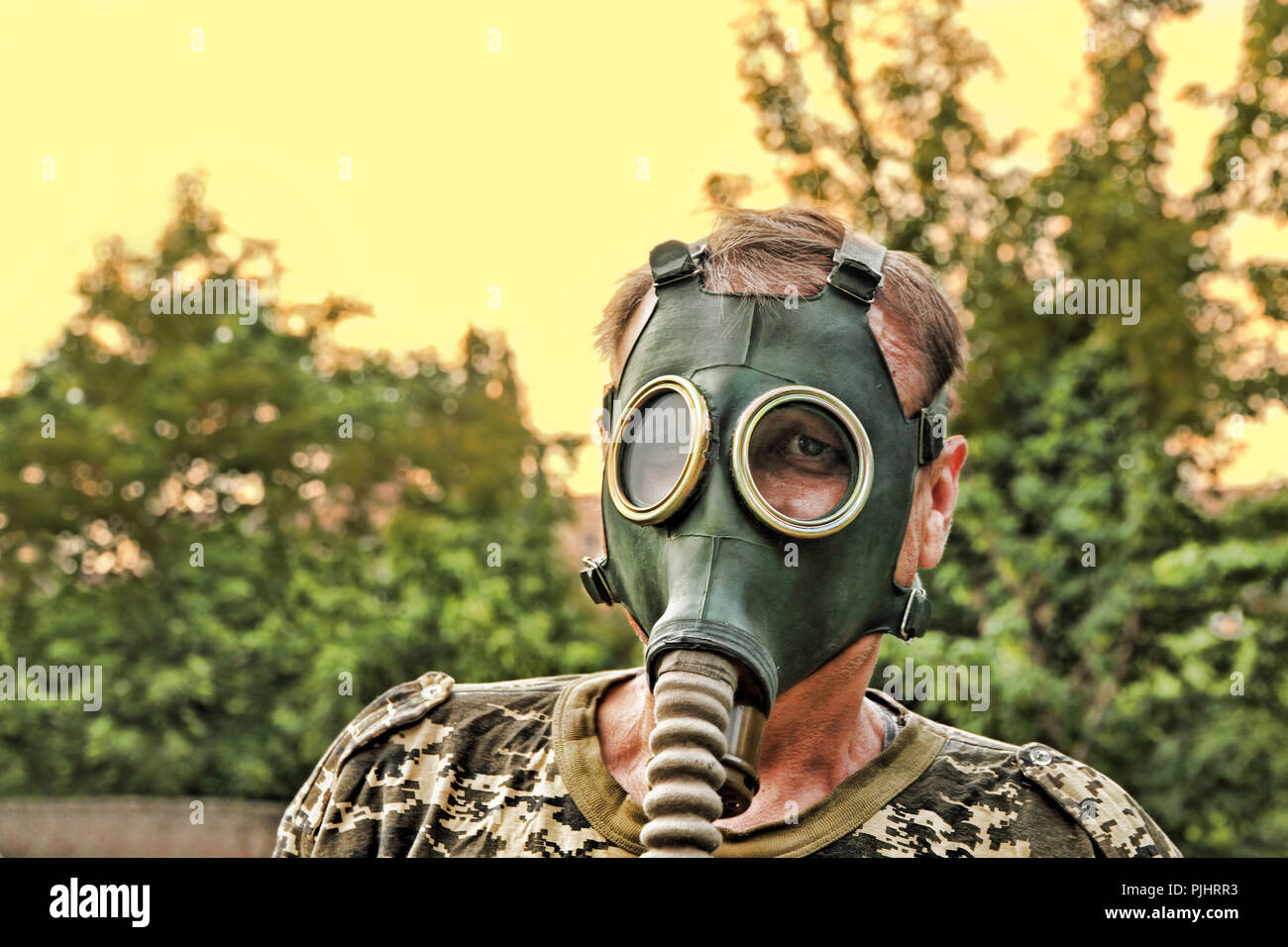 Men in gas mask at poisoned environment on chemical sky background ...