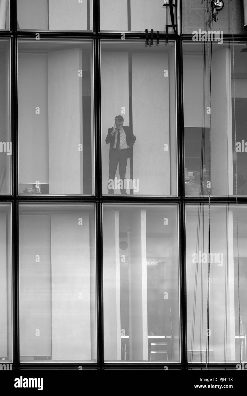 Managerial employee behind a glass facade Stock Photo - Alamy
