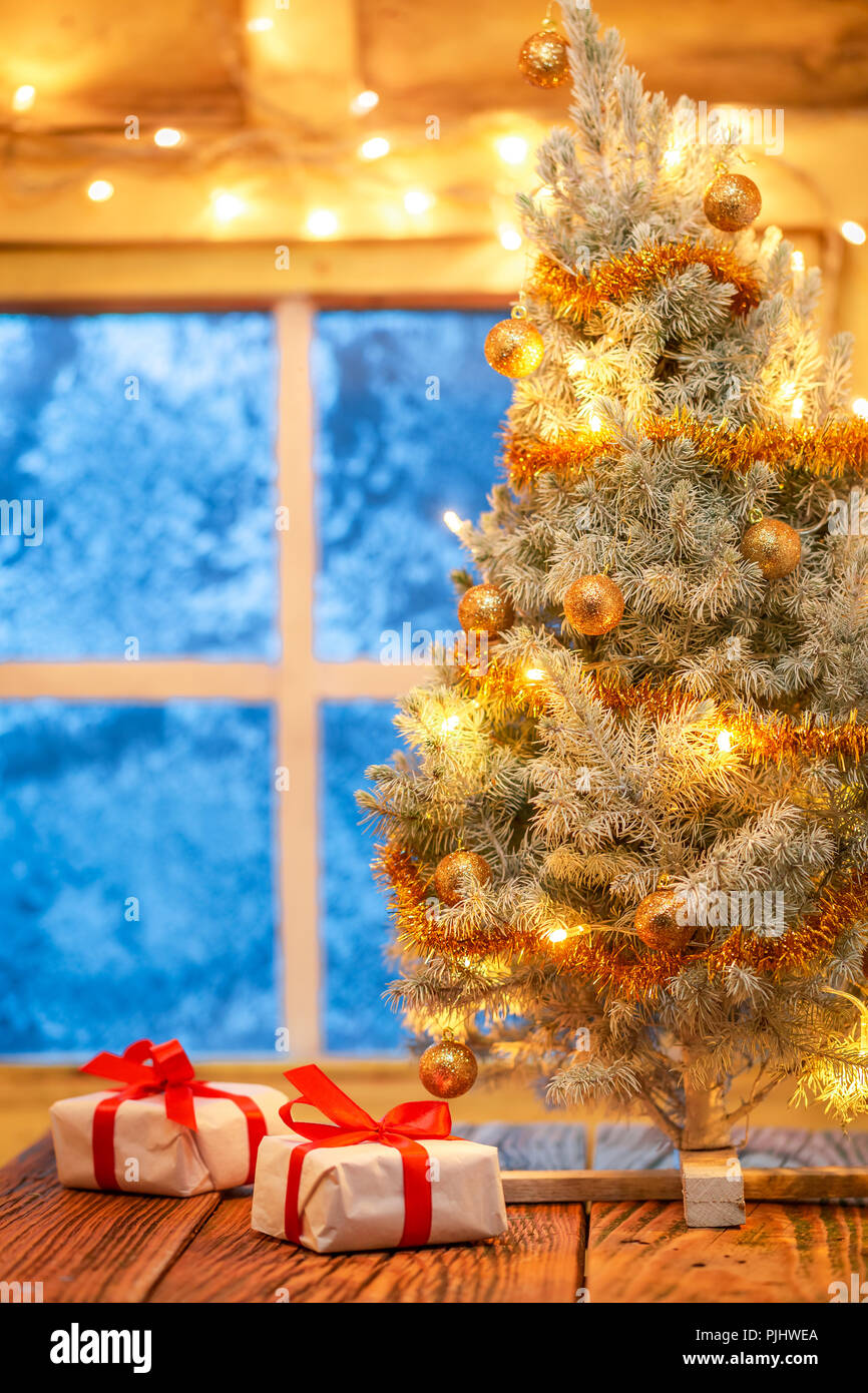 Adorable Christmas tree and gifts with frozen window and light Stock ...