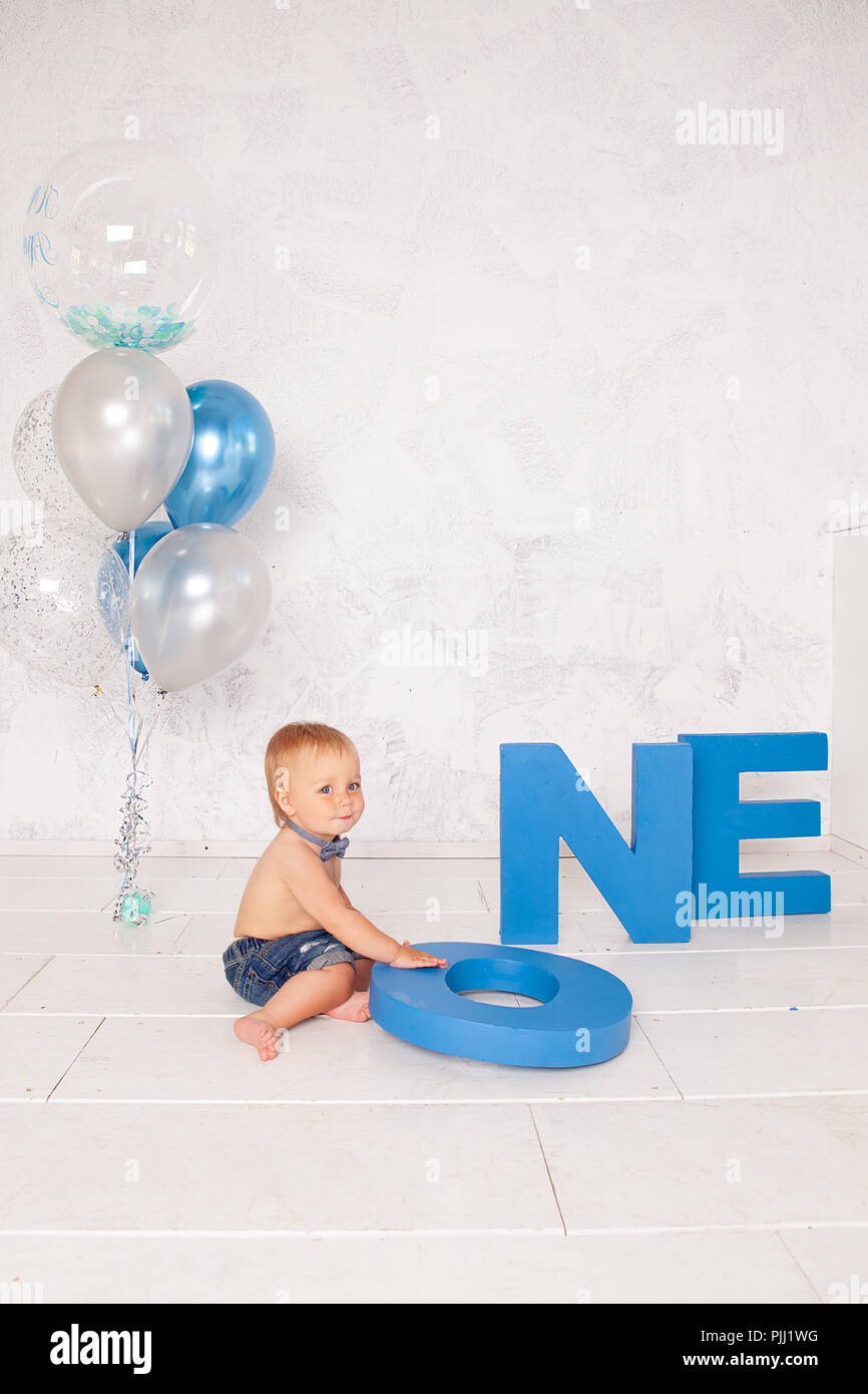 Portrait of fashion funny little boy in studio with big blue letters ...