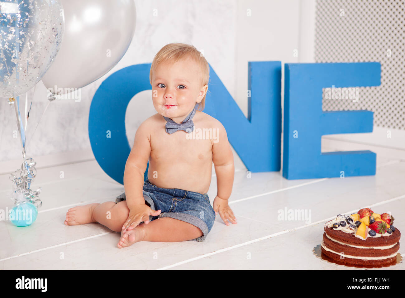 Portrait of fashion funny little boy in studio with big blue letters ...