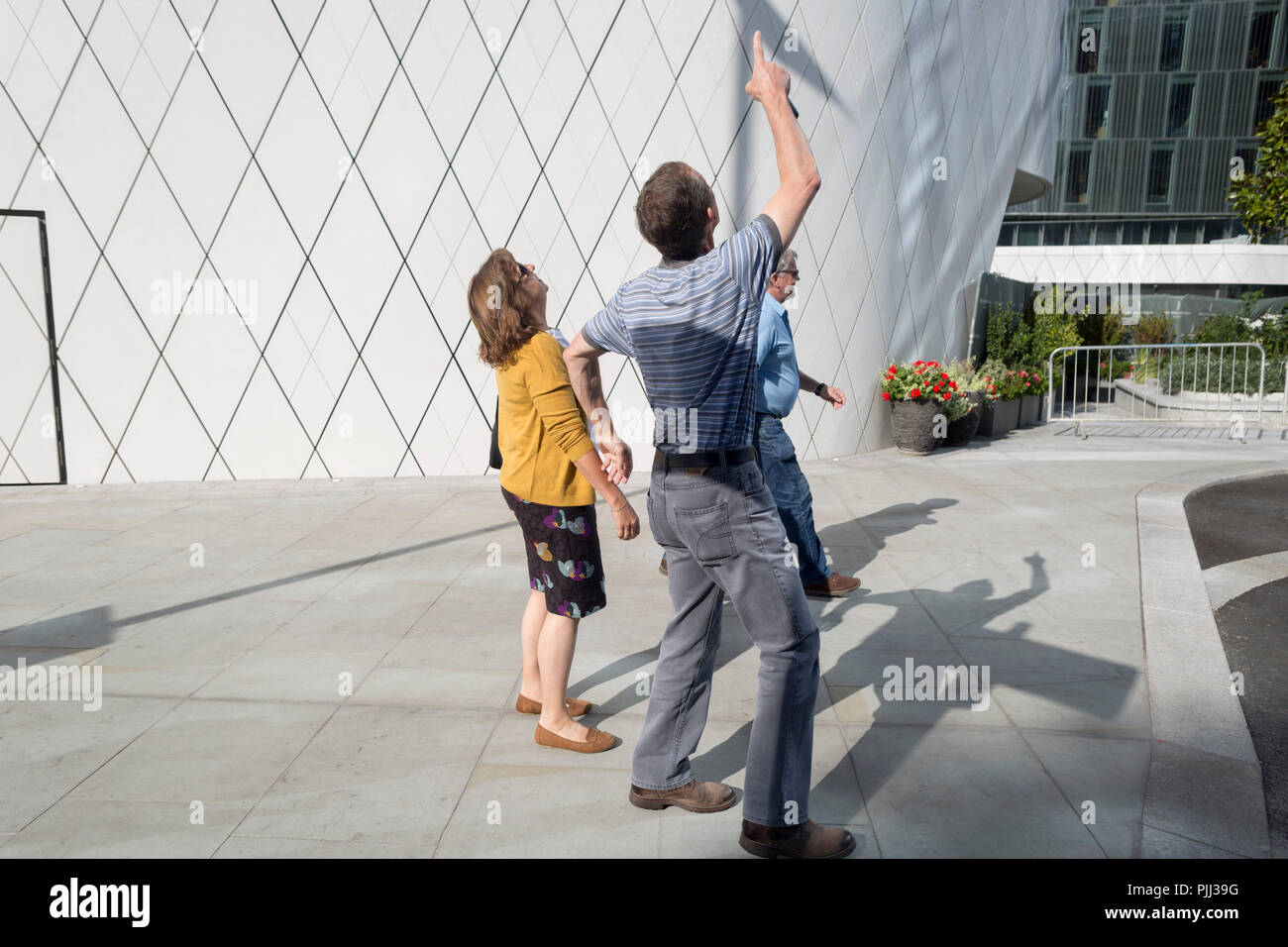 Pointing up to a tall new building with geometric angles and diagonal ...