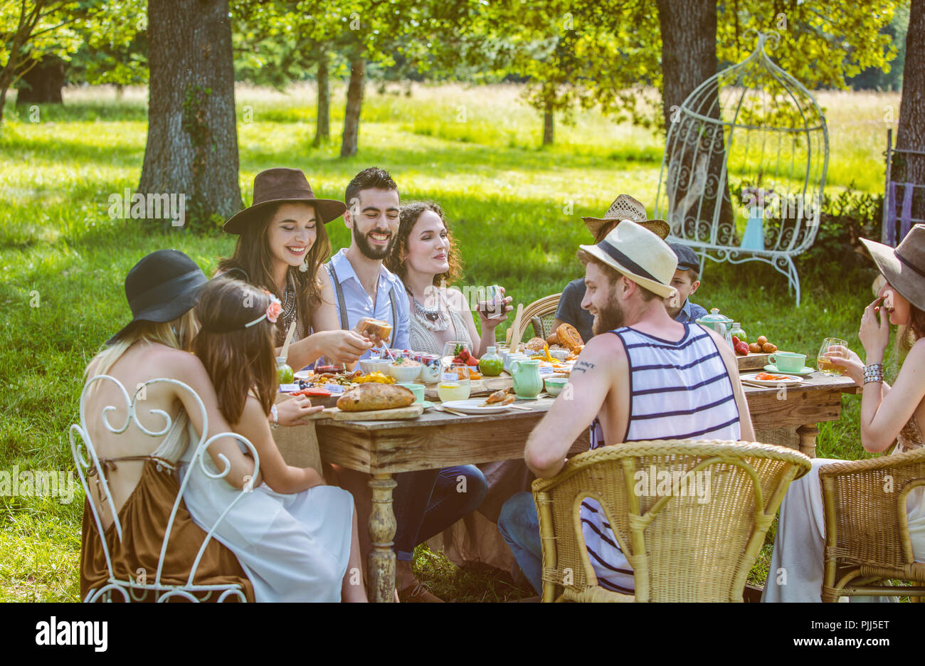 Group of young people seated at a brunch in the country. Mandatory ...