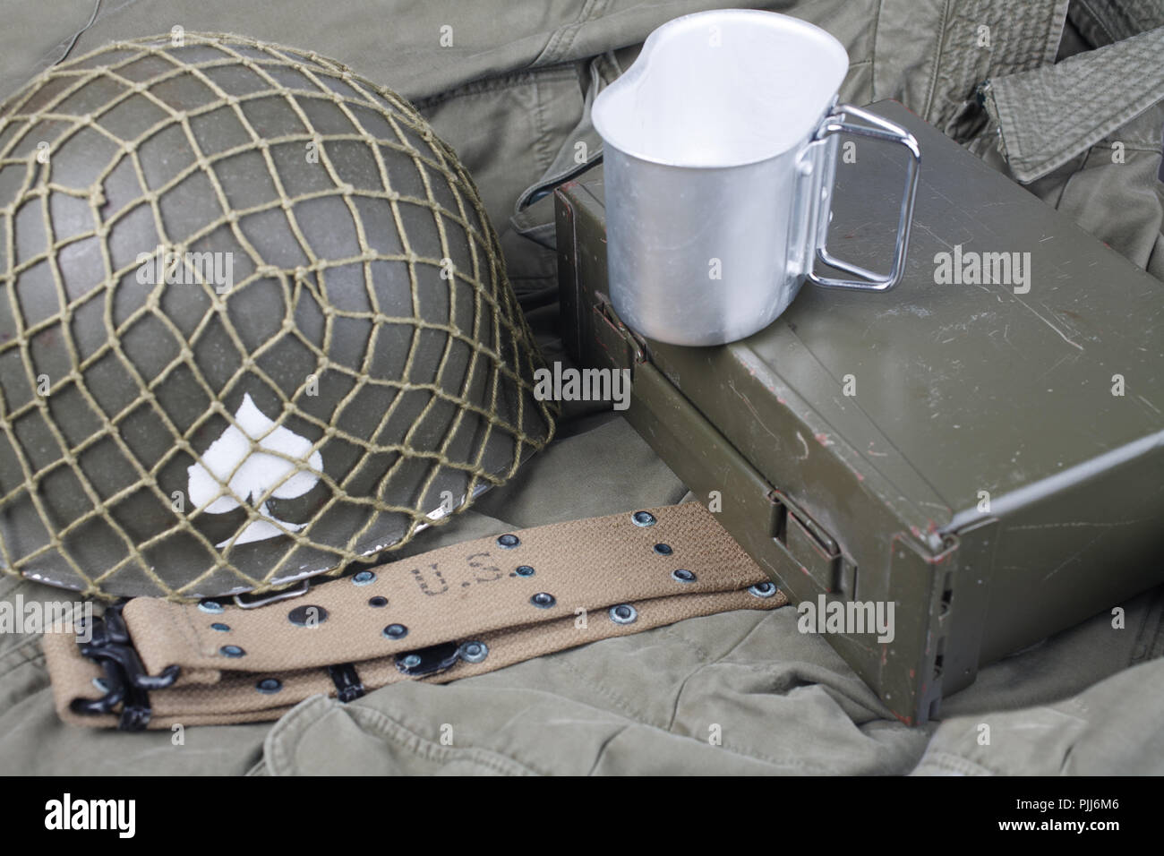 a cup of coffee with ww2 period us army military equipment on green ...