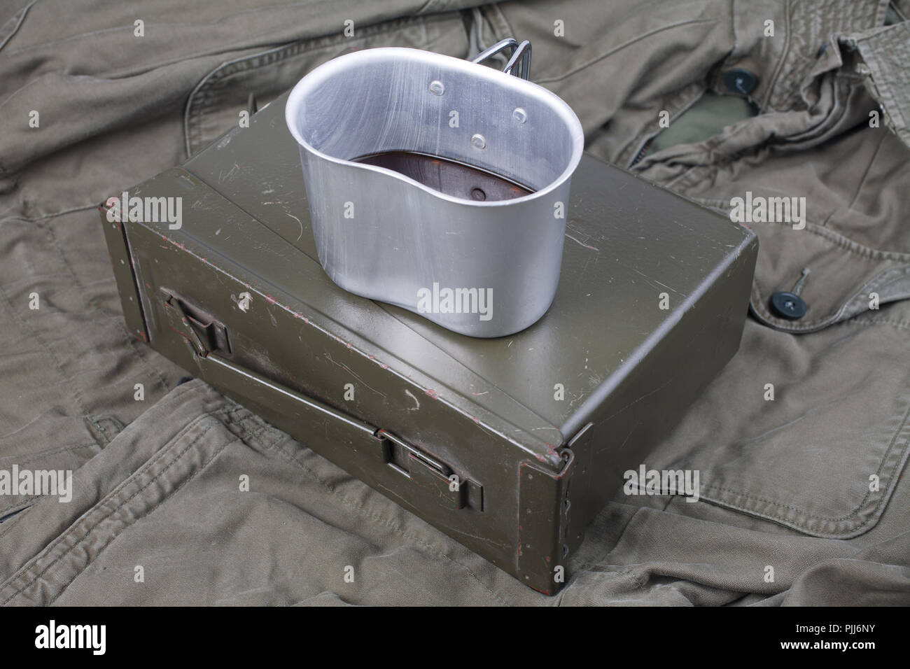 a cup of coffee with ww2 period us army military equipment on green ...
