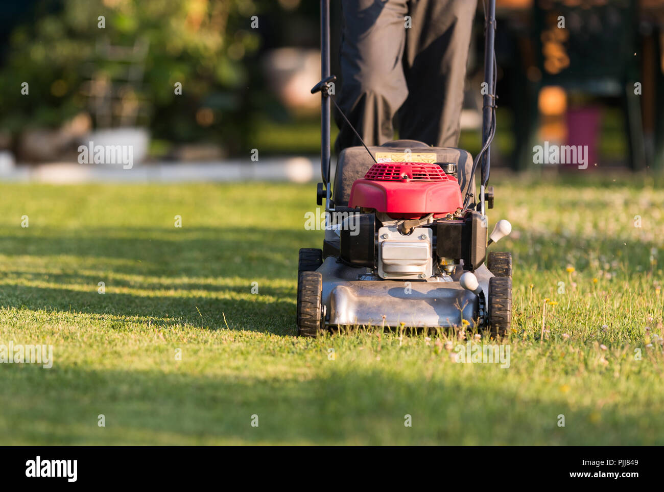Man pushing lawnmower hi-res stock photography and images - Alamy