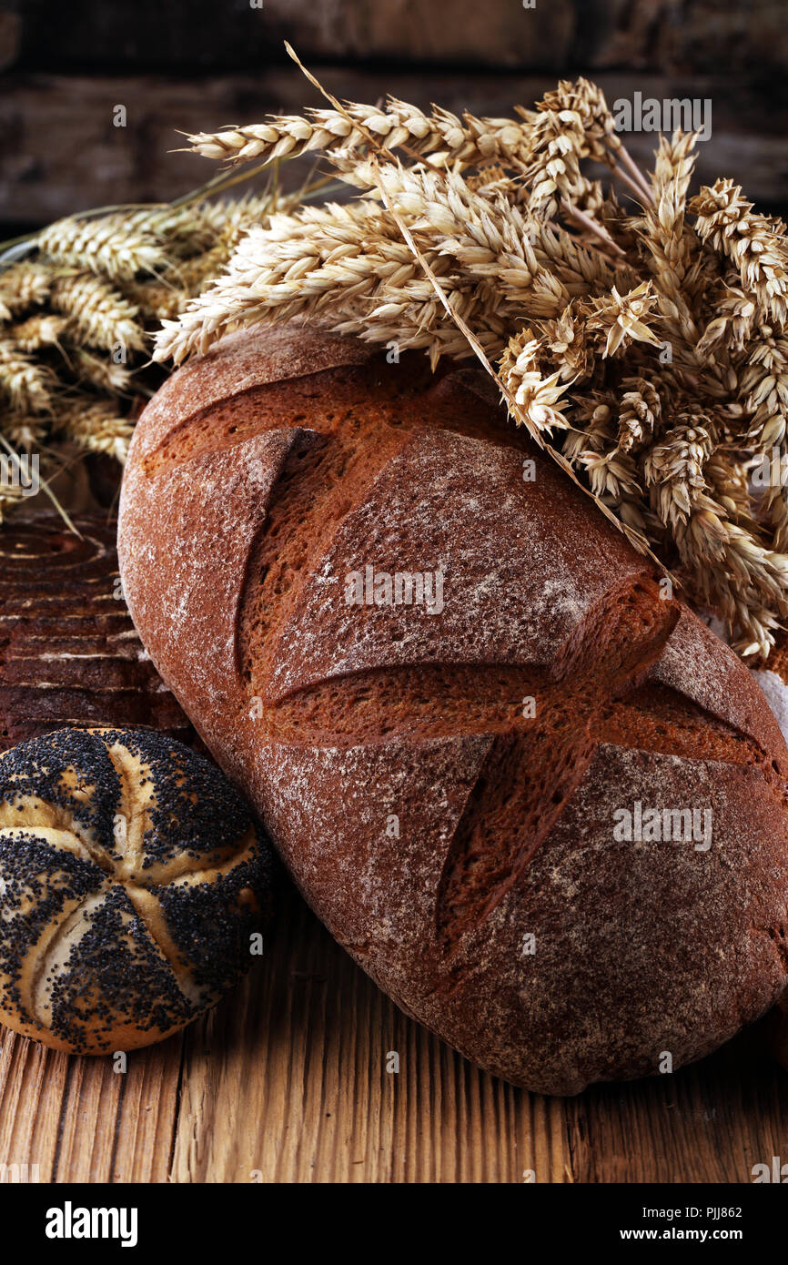 Different kinds of bread and bread rolls on board from above. Kitchen ...