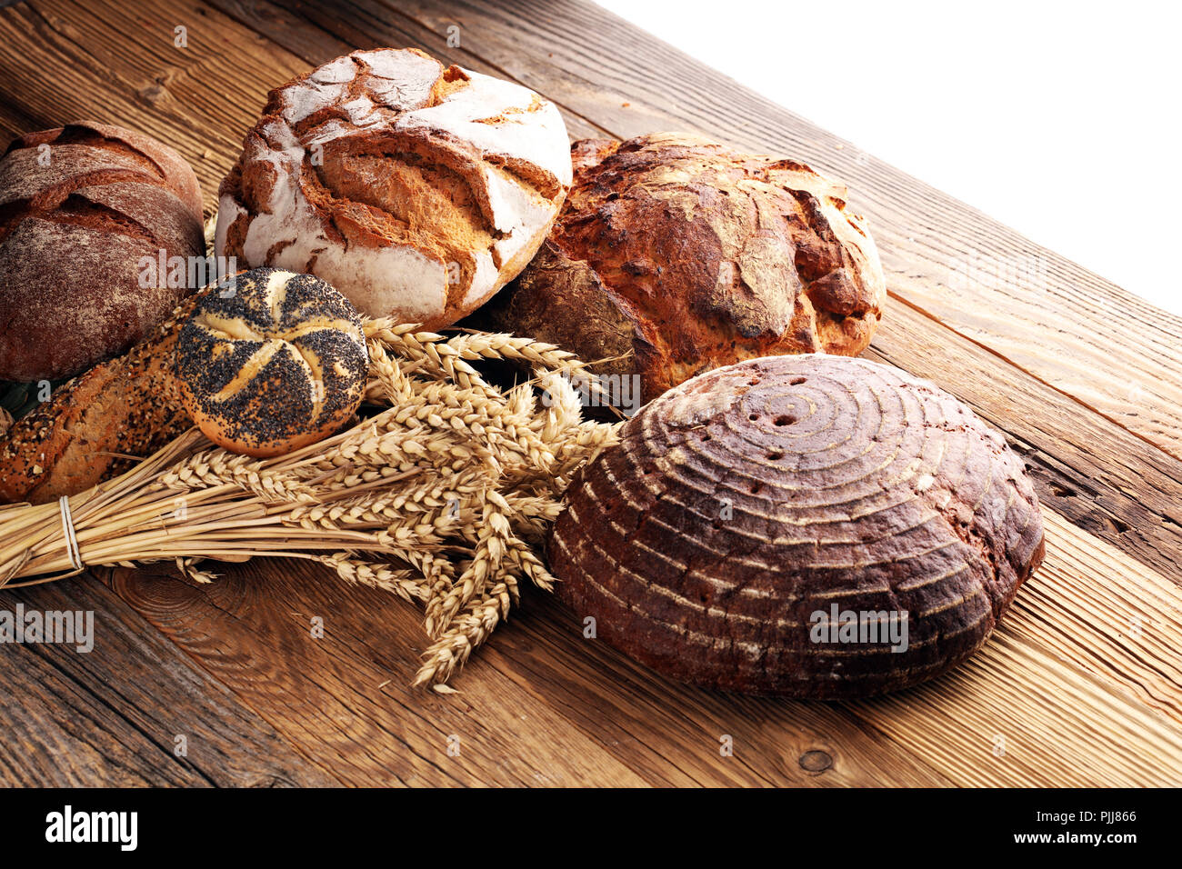 Different kinds of bread and bread rolls on board from above. Kitchen ...