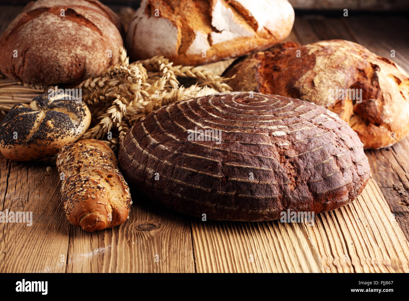 Different kinds of bread and bread rolls on board from above. Kitchen ...