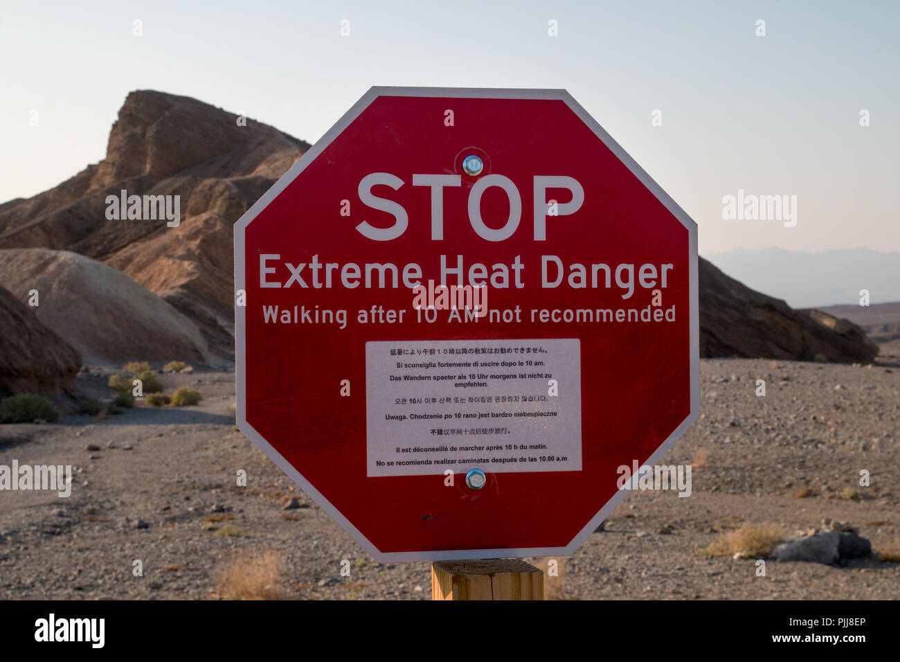 Warning sign indicating extreme heat danger in a desert location during ...
