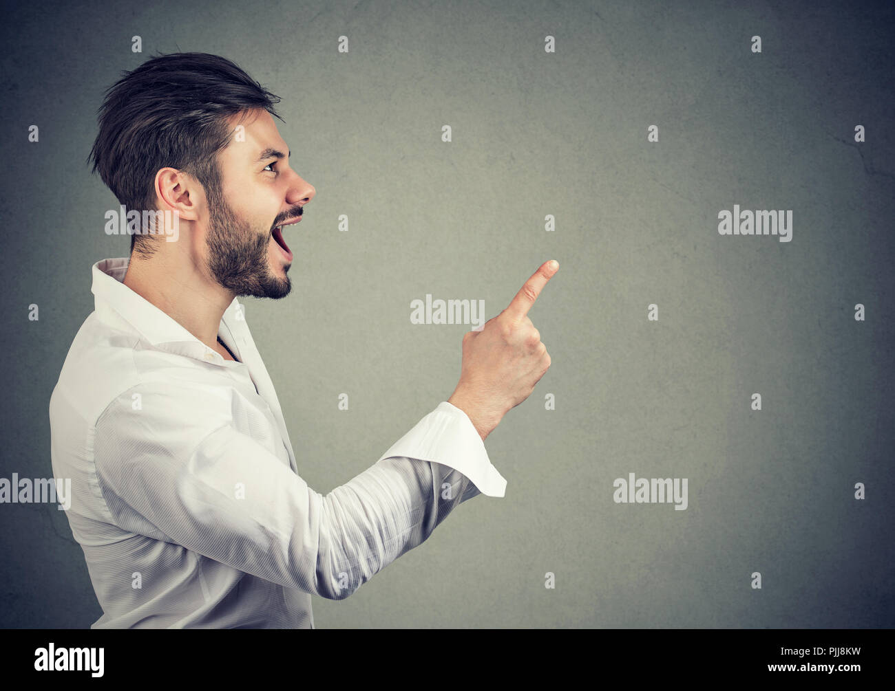 Side view of casual man in white shirt holding finger up having bright ...