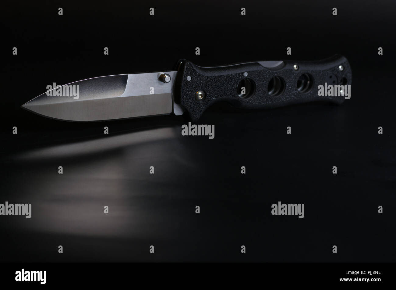 Knife and reflection. Black knife on a black background. Dark mood ...