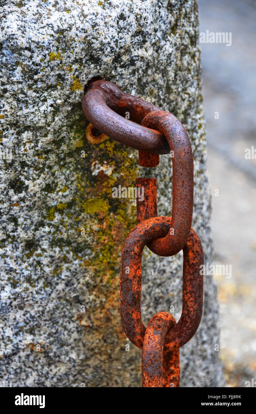 old rusty iron chain, hanging down, embedded in granite stone Stock ...