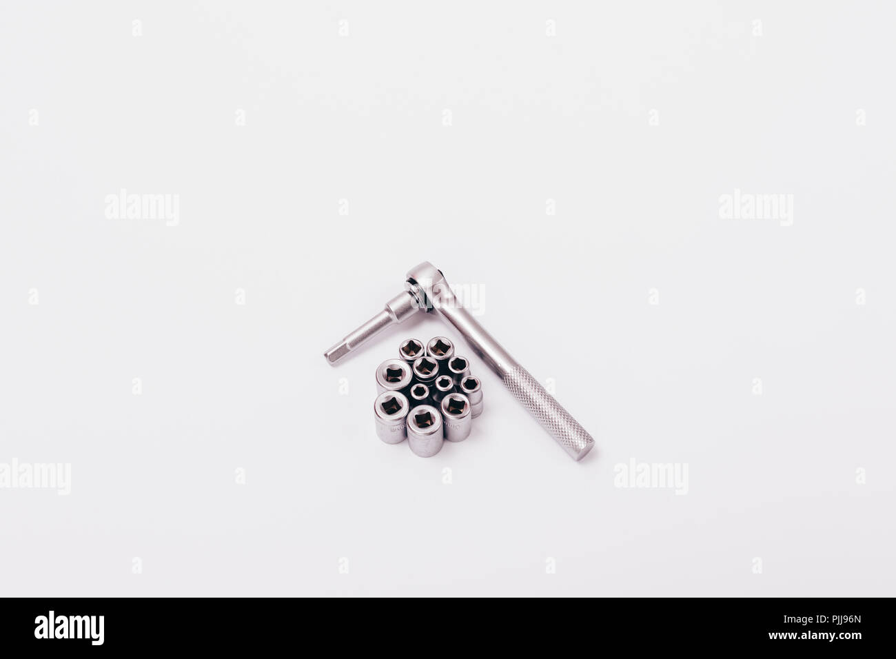 Wrench next to set of attachments of different diameters. Composition ...