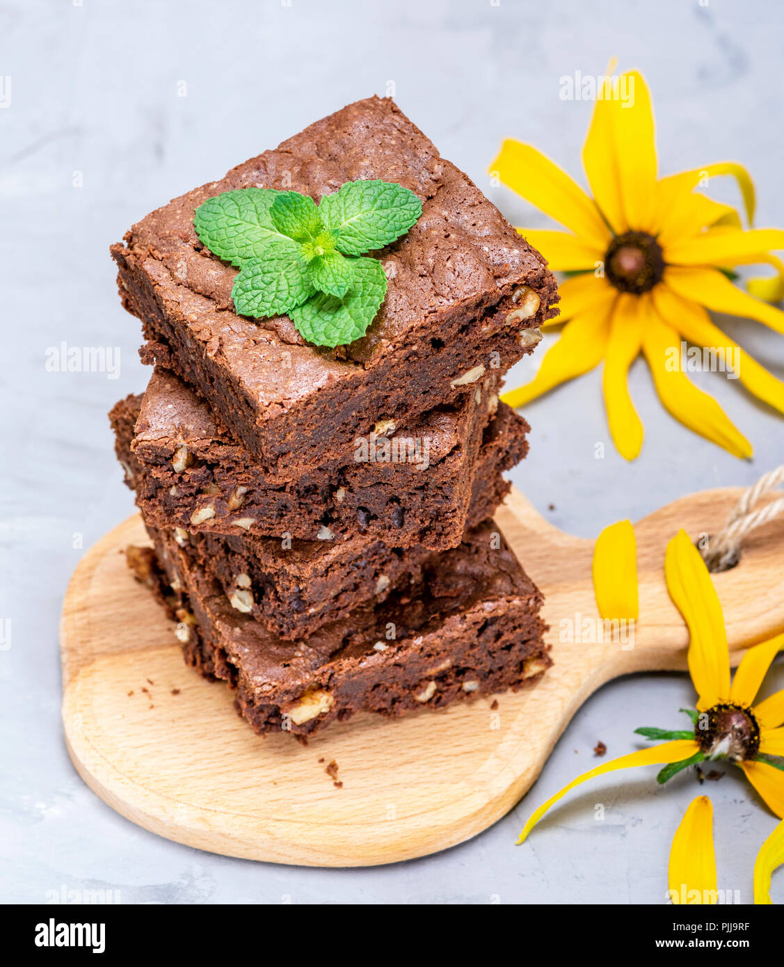 stack of baked square pieces of chocolate brownie pie with walnuts, top ...