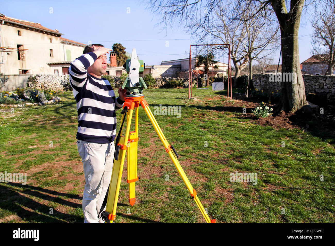 Man using of total station. Guy surveyor at work. Survey Instrument ...