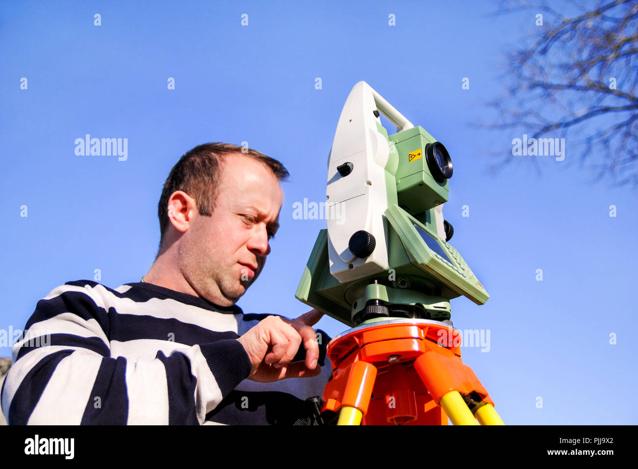 Man using of total station. Guy surveyor at work. Survey Instrument ...