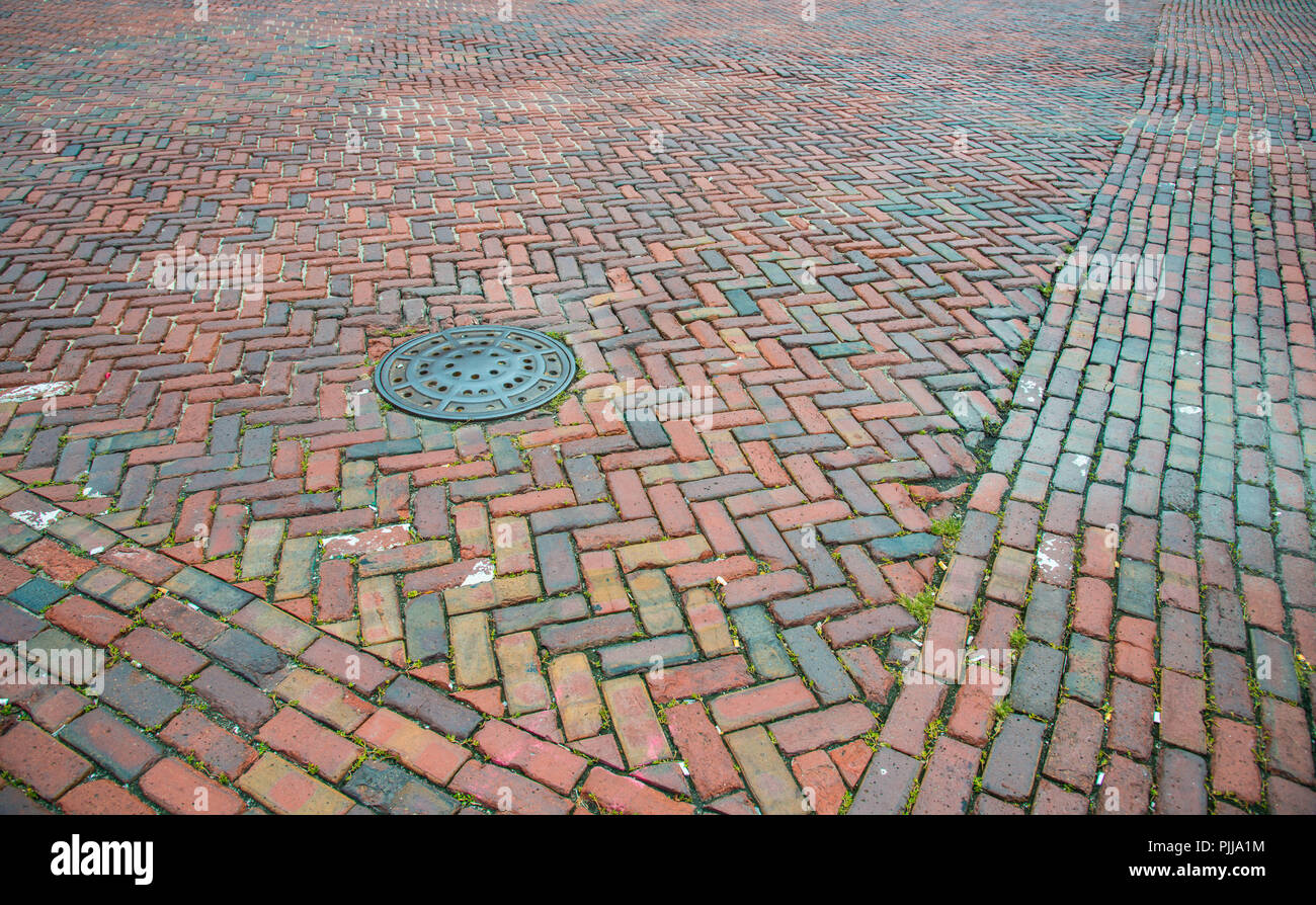 Old Brick street with a manhole cover that is well worn Stock Photo - Alamy