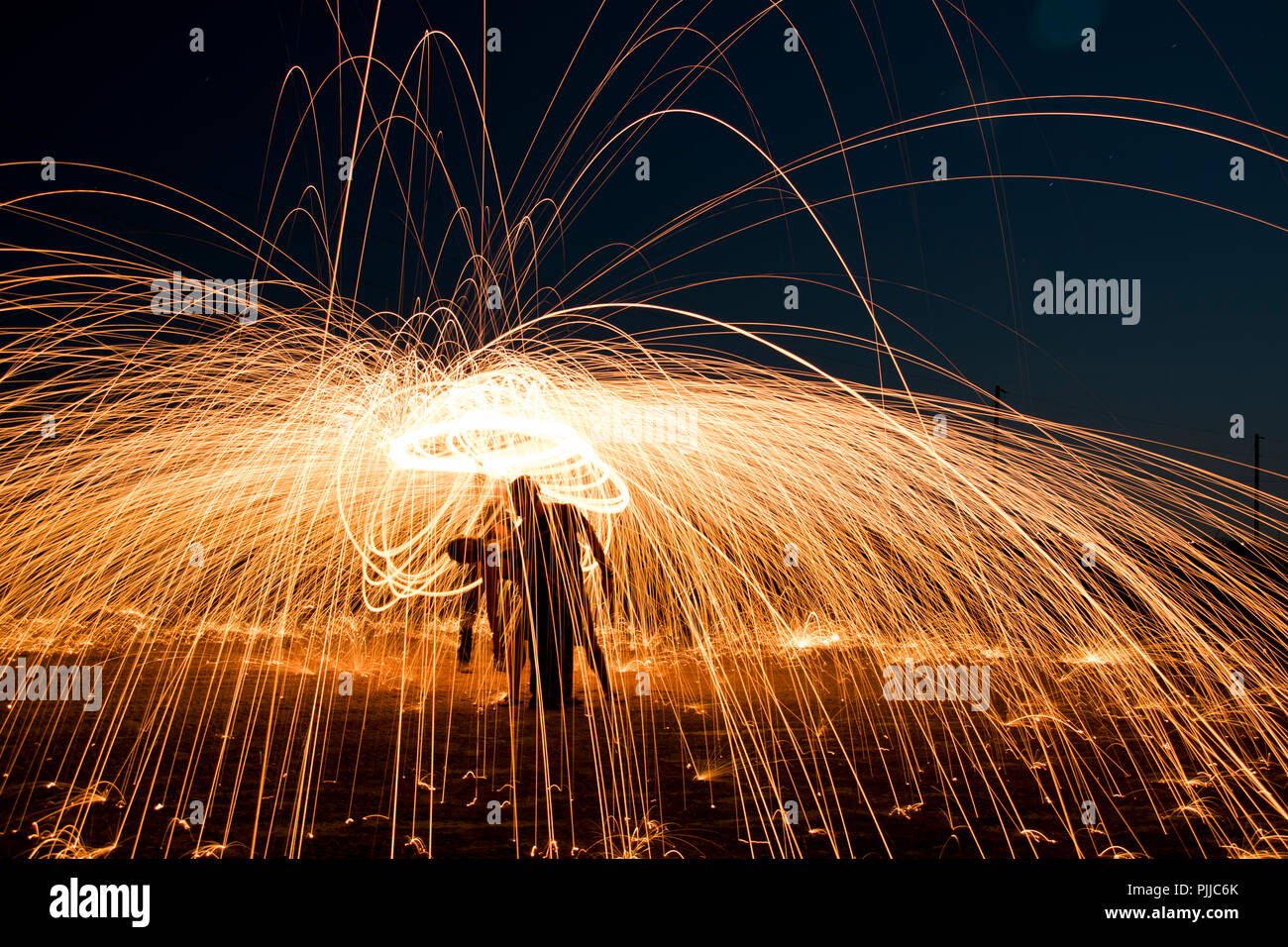 Couple dancing with sparks of fire flying in the air. Artistic steel ...