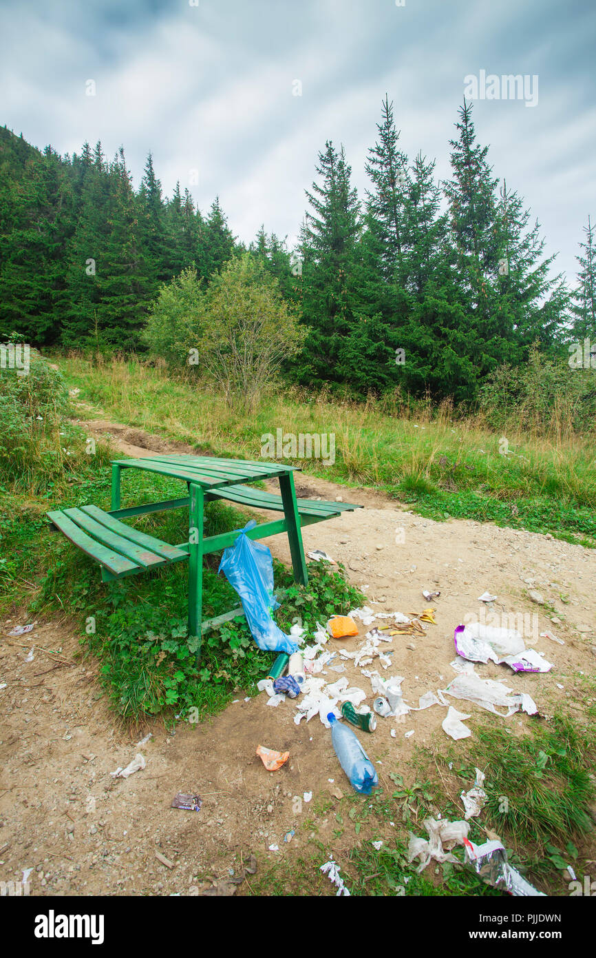 trash and garbage near bench in mountain forest landscape, nature or ...