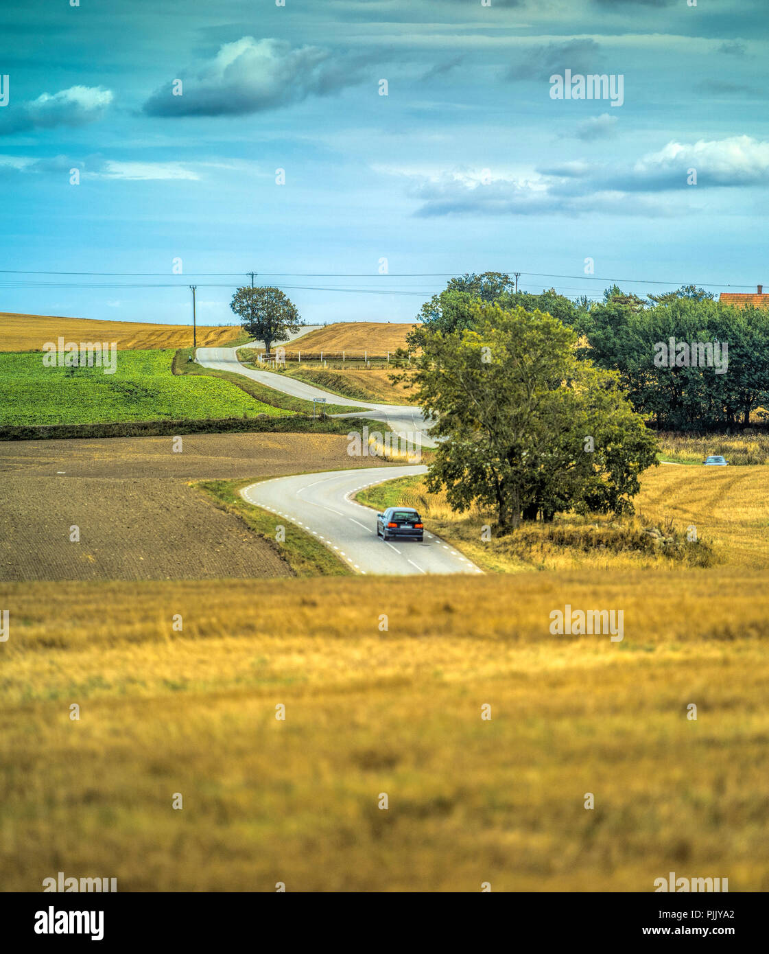 A winding road in Swedish rural landscape Stock Photo - Alamy