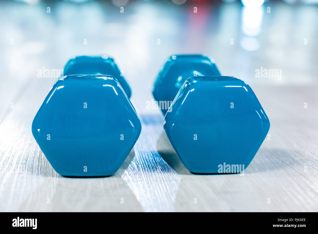 Blue modern dumbbells on a wooden floor Stock Photo - Alamy