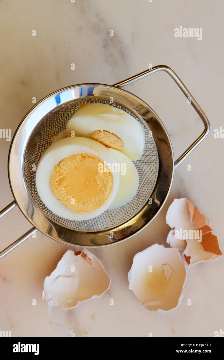 Hard boiled egg and shell in a kitchen sieve Stock Photo - Alamy