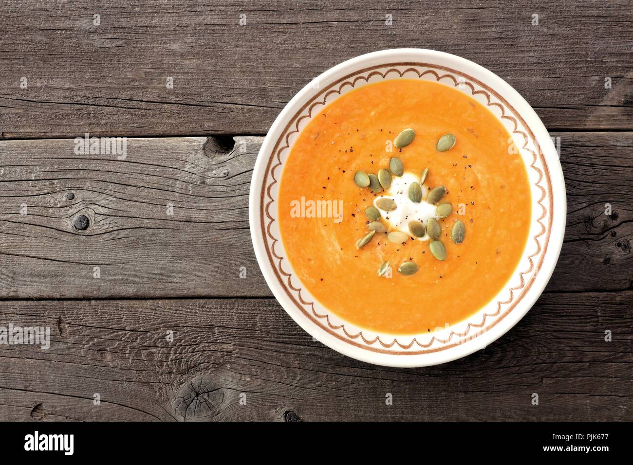 Creamy butternut squash soup, above view on a rustic wood background ...