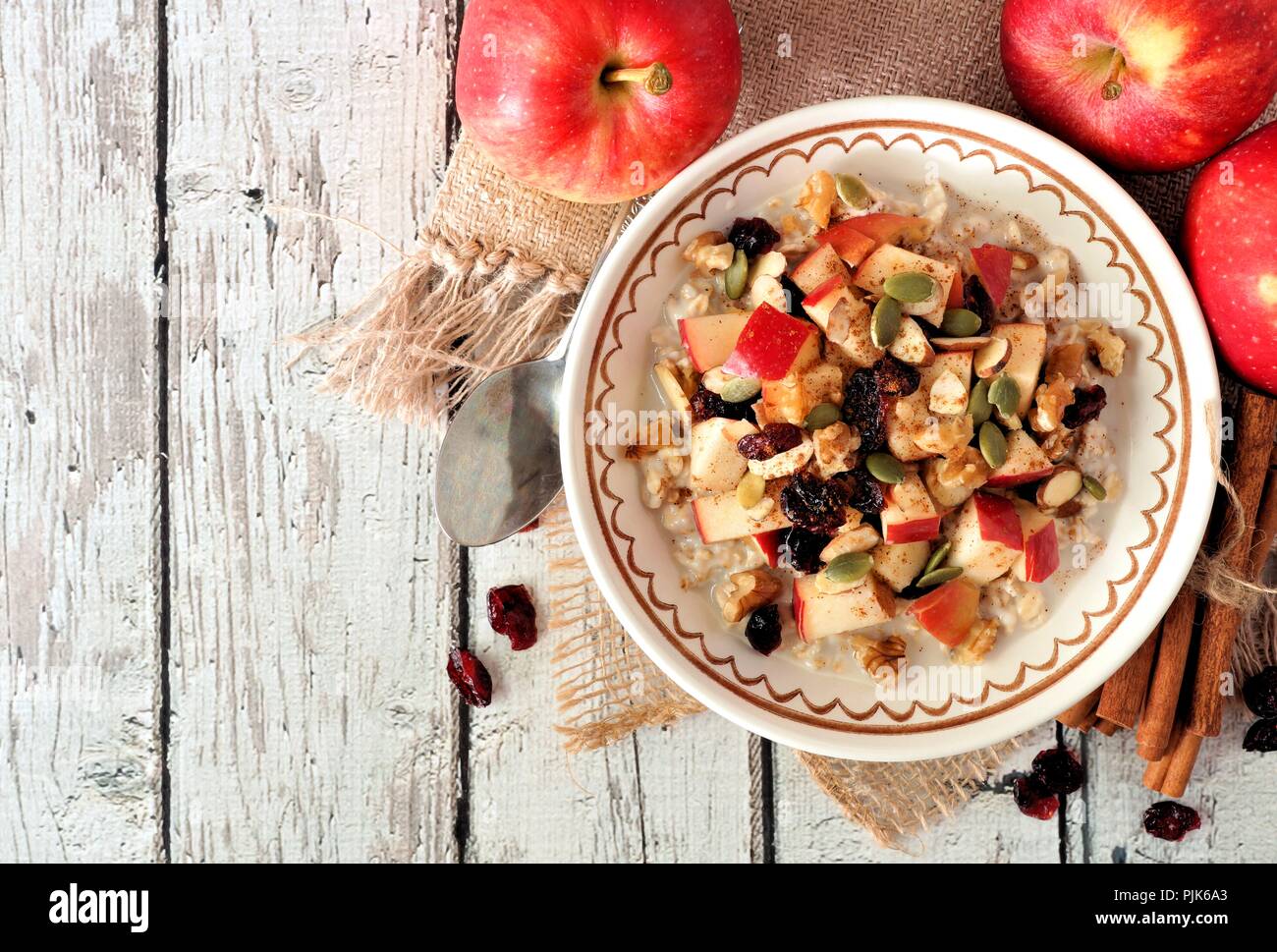Autumn oatmeal with apples, cranberries, seed and nuts, overhead table ...