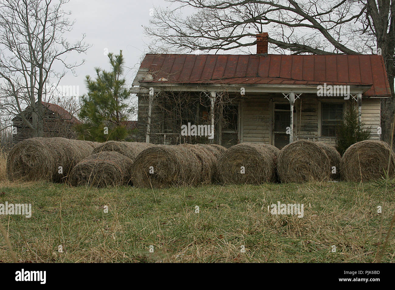 Old abandoned house with hay bales in the yard. Virginia's countryside ...