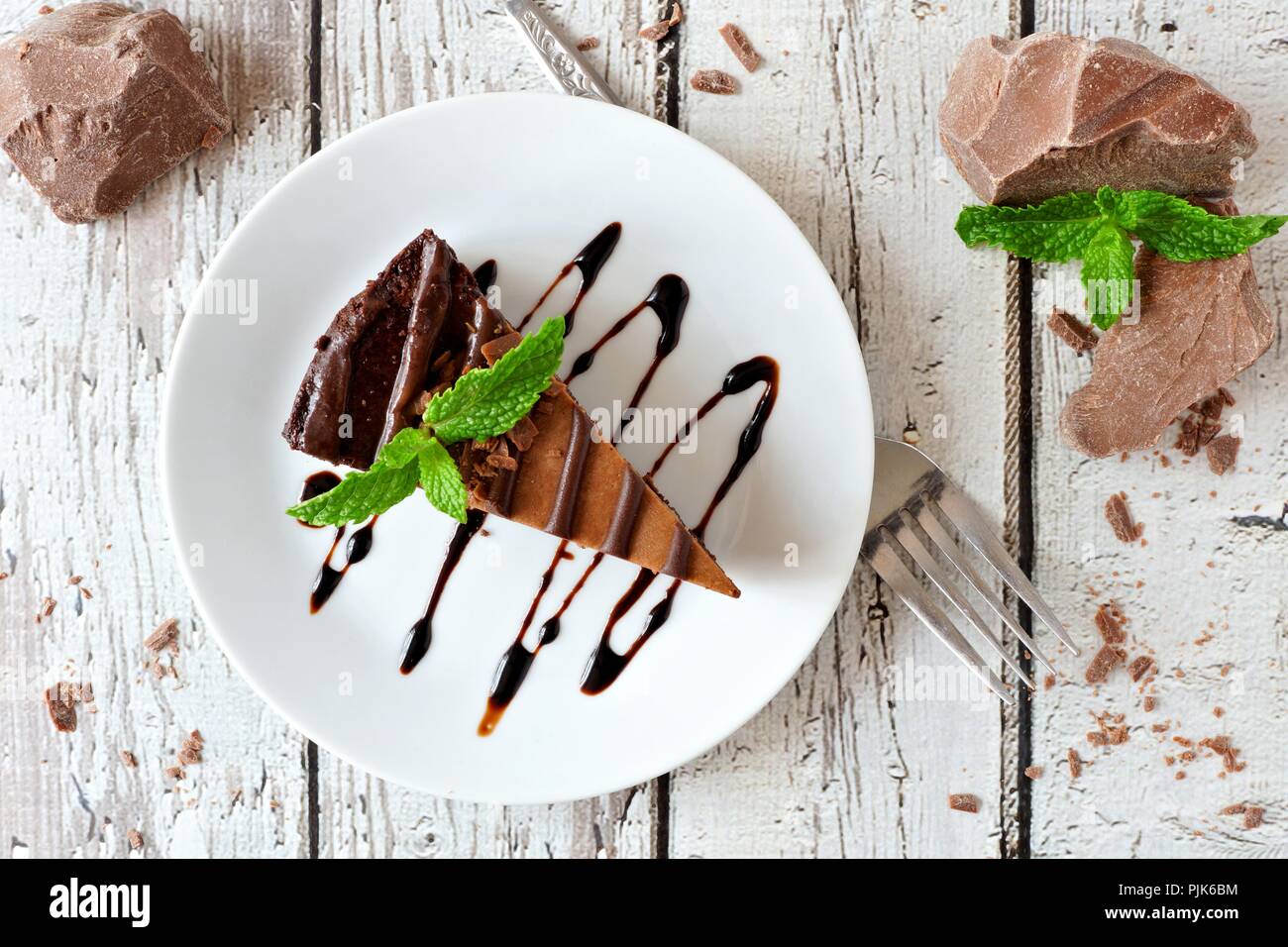 Slice of chocolate cheesecake on plate, above view over a rustic white ...