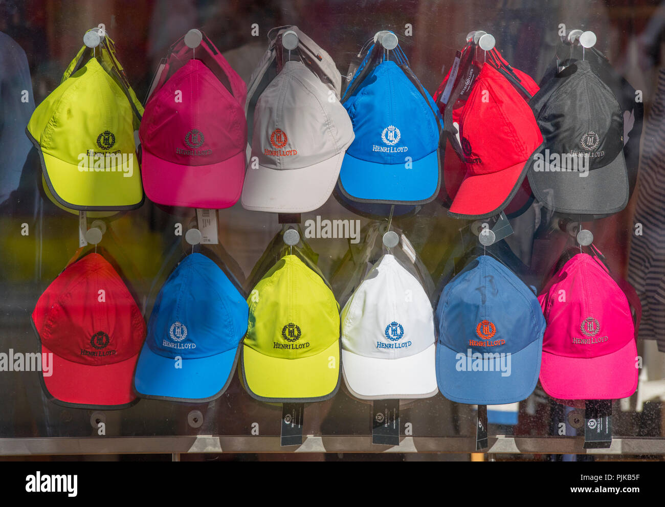 rows or lines of colourful selection of baseball caps hanging in a shop ...