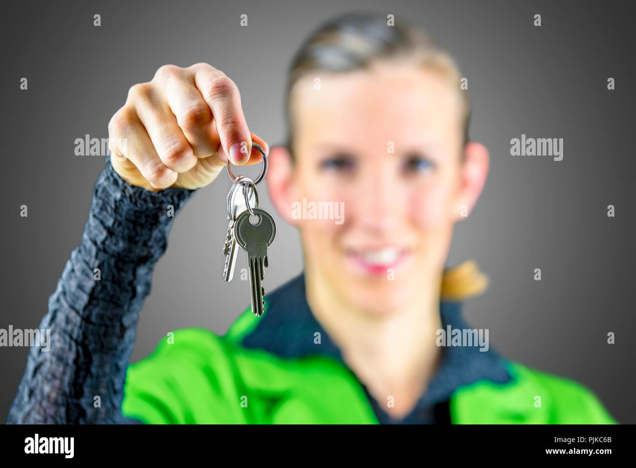Young female real estate agent offering you house keys Stock Photo - Alamy